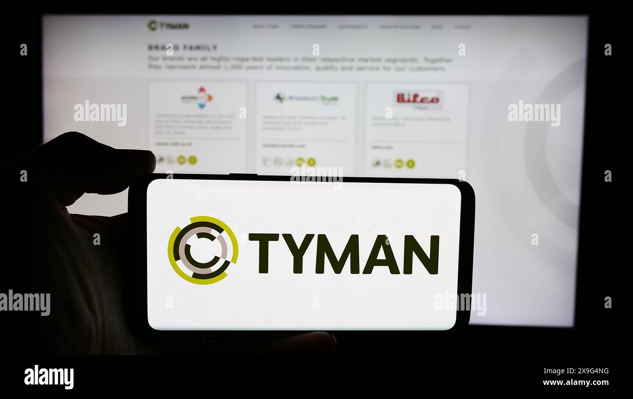 Person holding cellphone with logo of British building products company ...