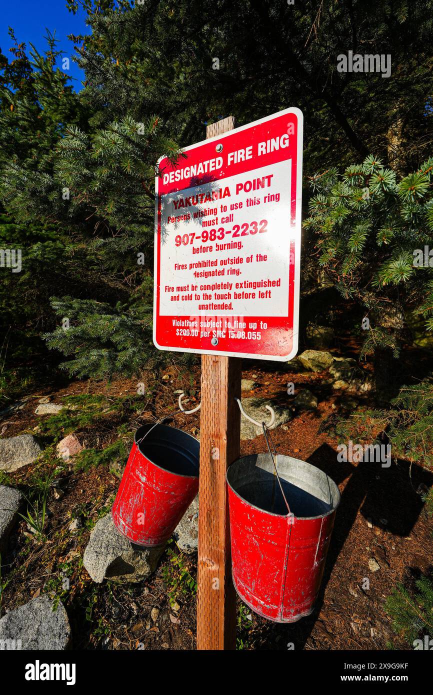 Pole with red buckets to extinguish a campfire near a designated fire ...