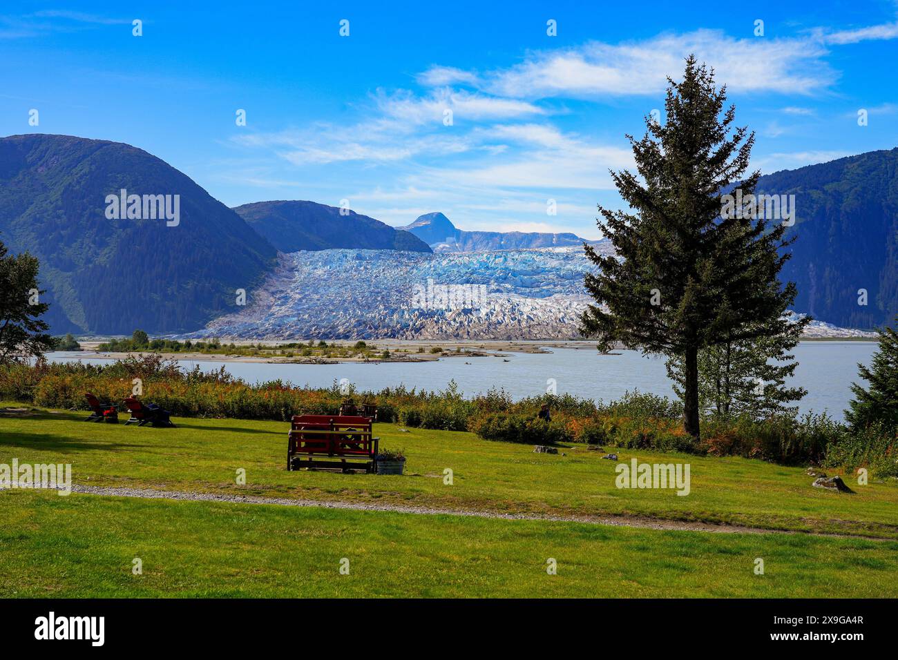 Landscaped park with relaxing benches facing the Taku Glacier across a ...
