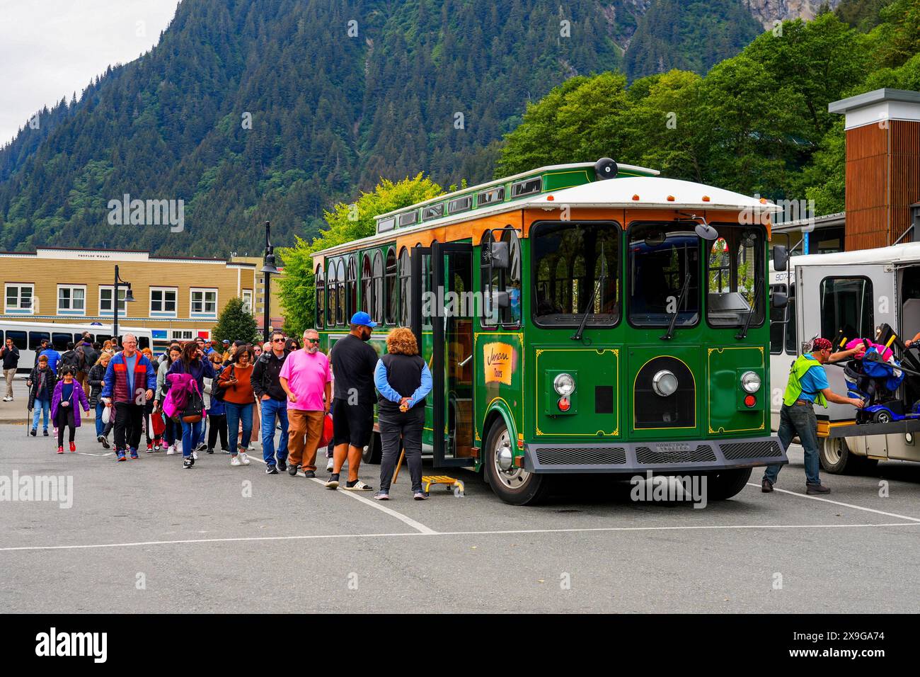 Tourists boarding a vintage green coach heading for a sightseeing tour ...
