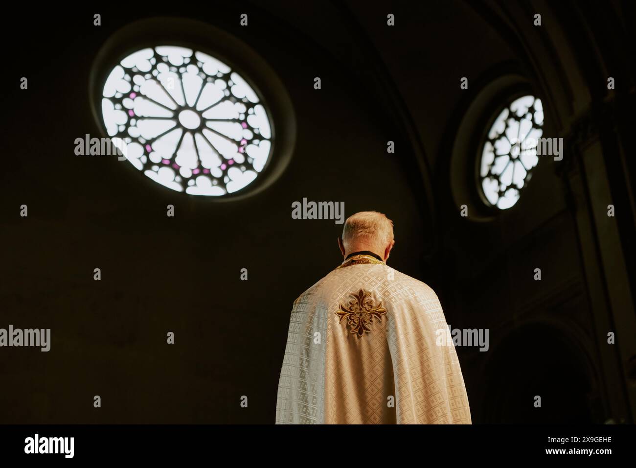 Rear view low angle shot of unrecognizable elderly Catholic priest ...
