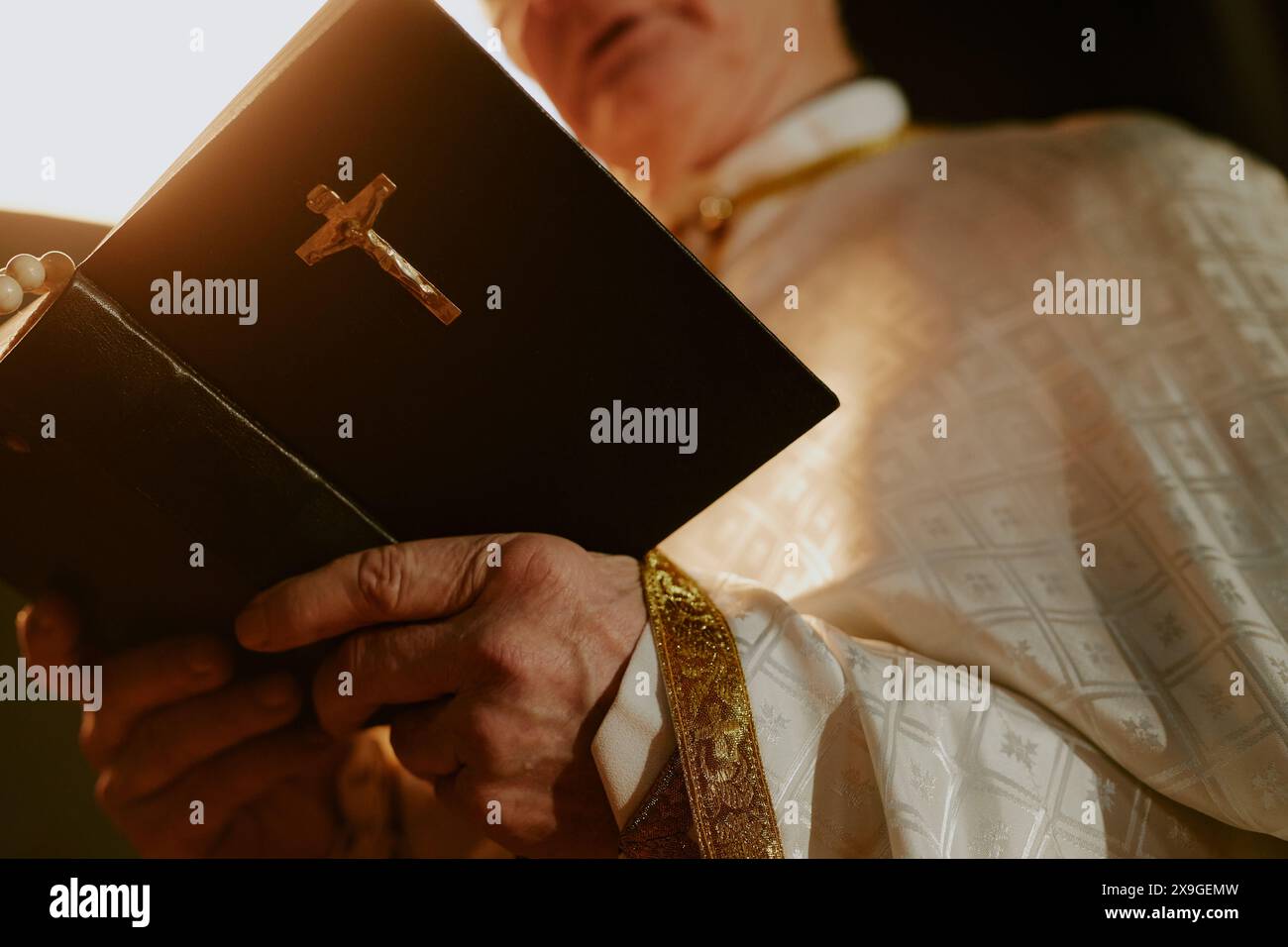 Low angle view closeup of unrecognizable senior preacher reading Bible ...