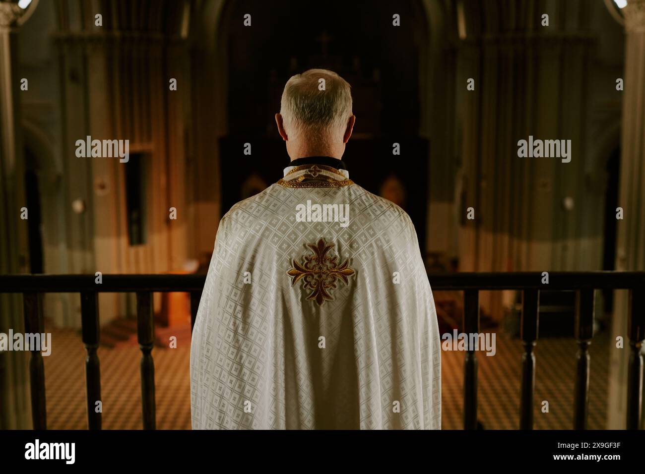 Rear view of unrecognizable senior Catholic priest wearing vestment ...