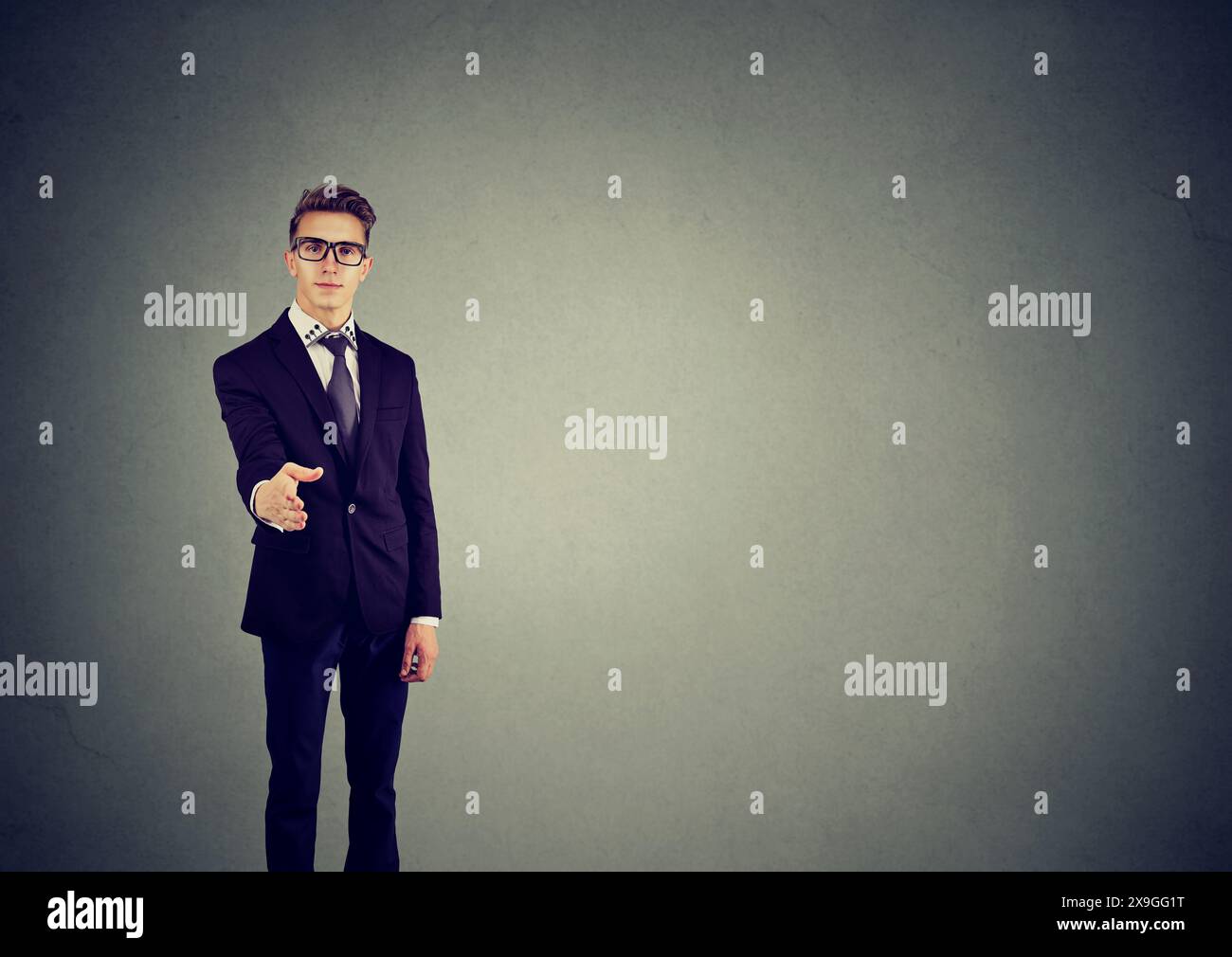 Serious business man giving a handshake Stock Photo - Alamy