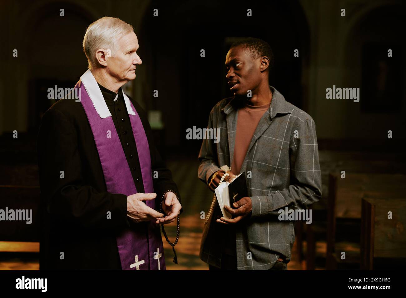 Medium shot of Caucasian Catholic priest and African American ...