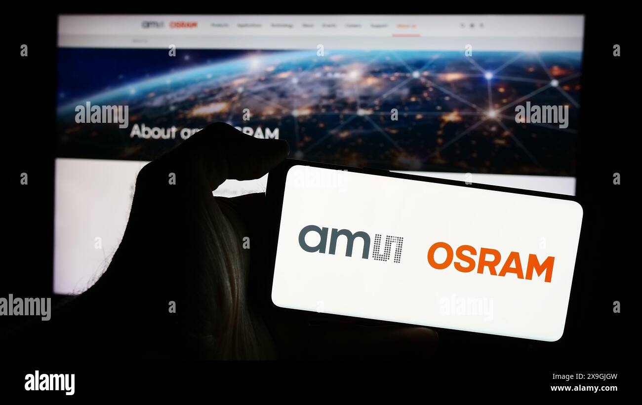 Person holding mobile phone with logo of Austrian electronics company ...