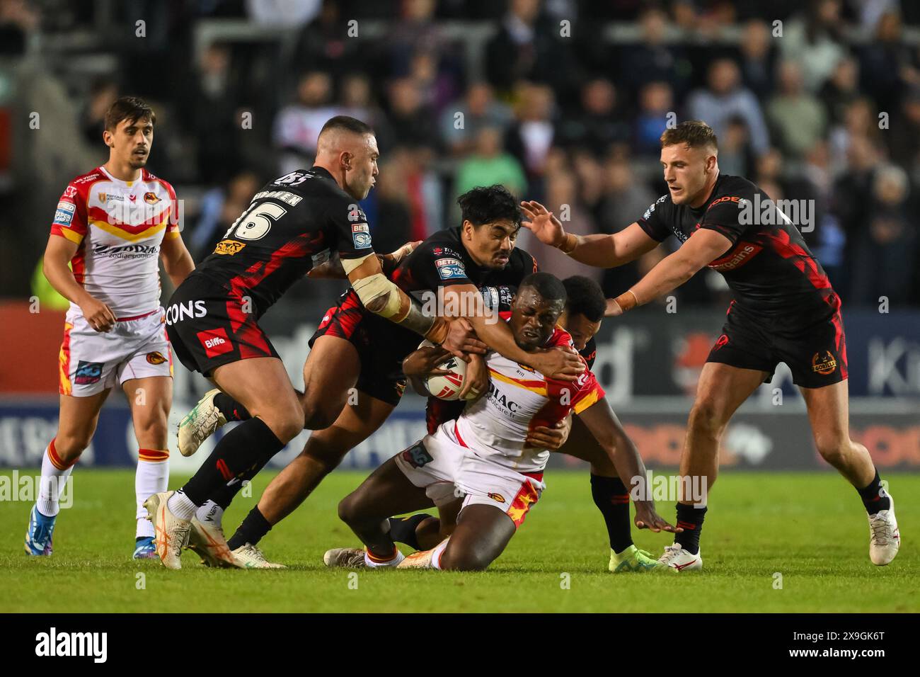 Jordan Dezaria of Catalan Dragons is tackled by James Bell of St ...