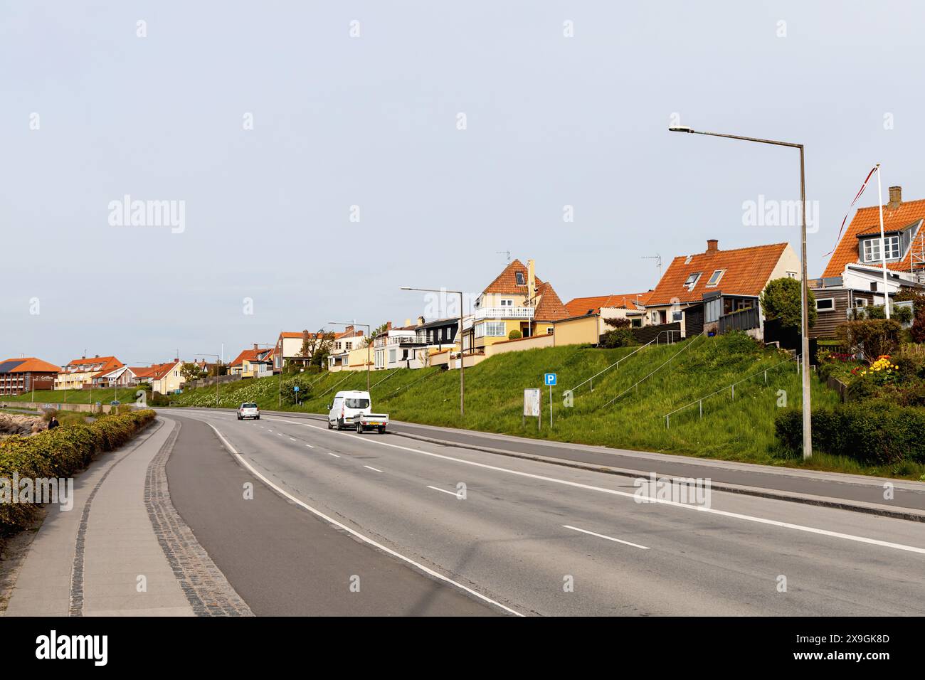 Asphalt highway and residential buildings on the island of Bornholm ...
