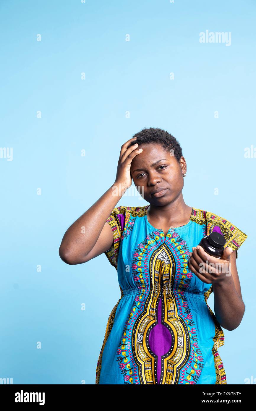 Exhausted sick woman reads medicine bottle label to take painkillers ...