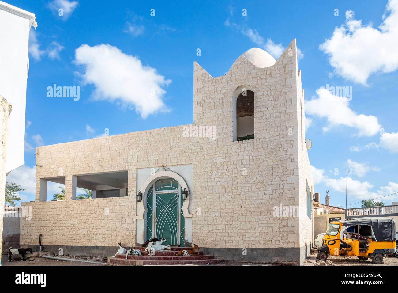 White mosque on the street of Tajoura with goats at the entrance ...