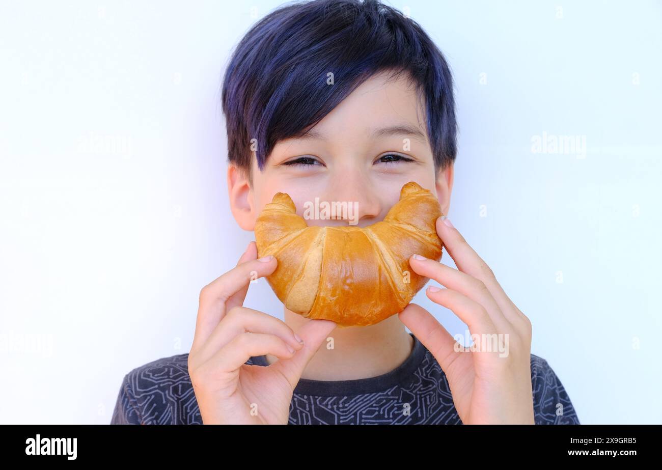 close-up of child's face, boy of 10 years old holds rosy baked ...
