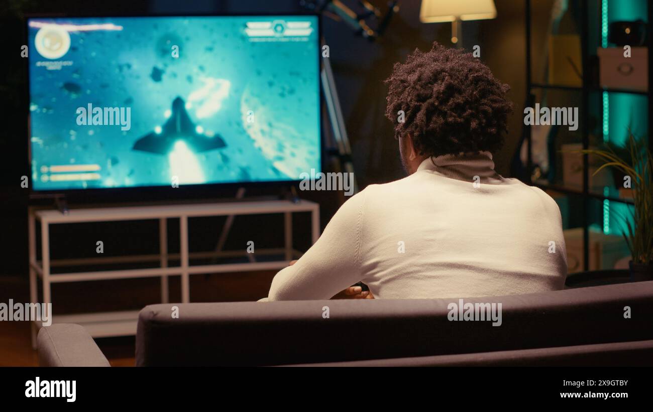 Gamer plays multiplayer game with spaceship shooting laser streams ...