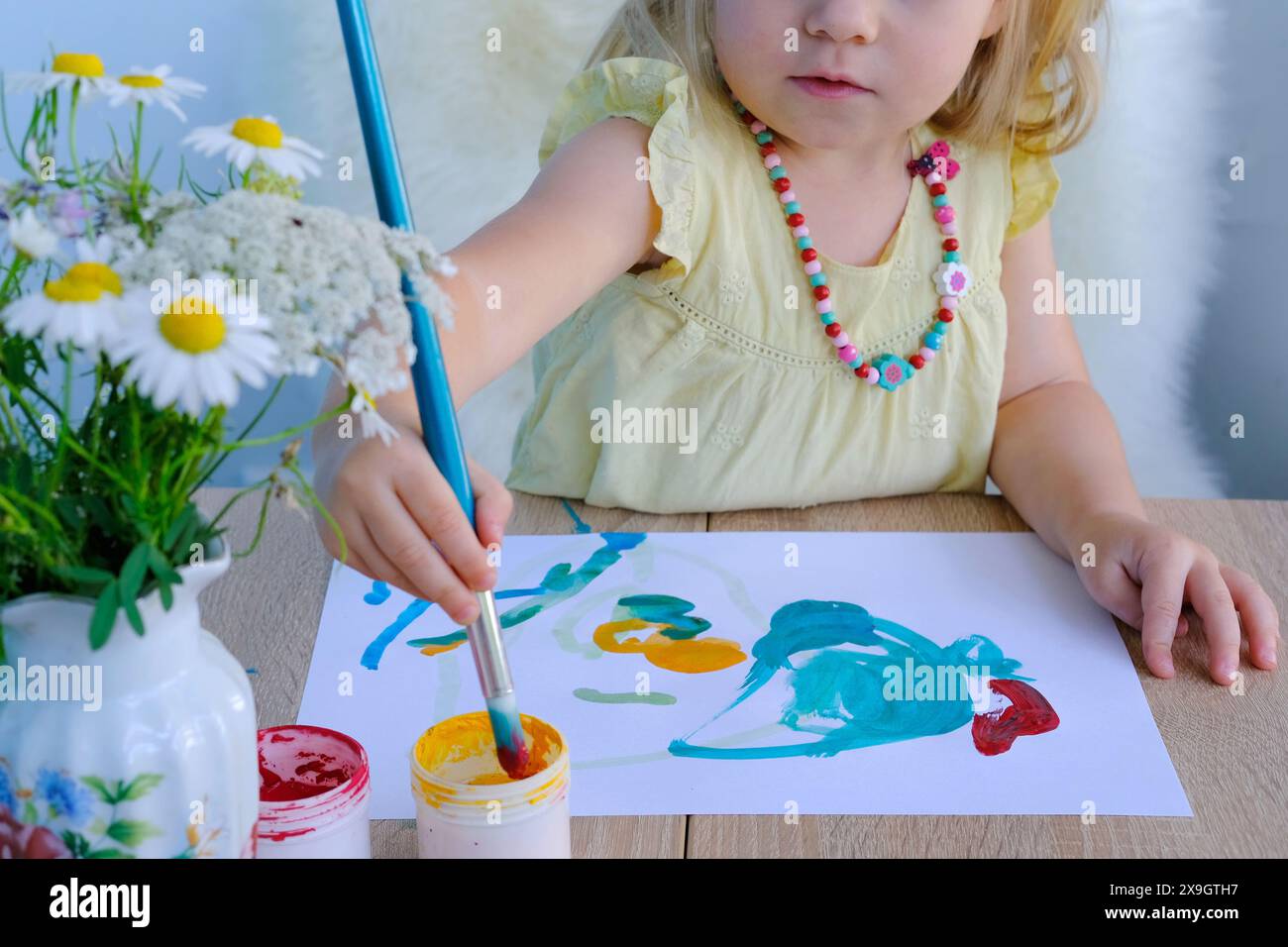 children's hand paints with brush, small child, little girl preschooler ...
