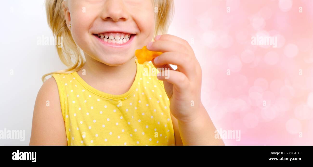 cheerful small child holds sweets, blonde girl 3 years old wants eat ...