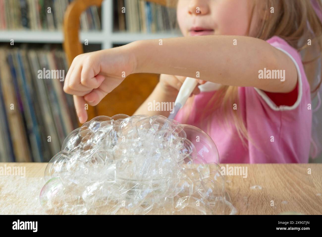 Little girl blows bubbles made of soap foam, bursts, kids fun games ...