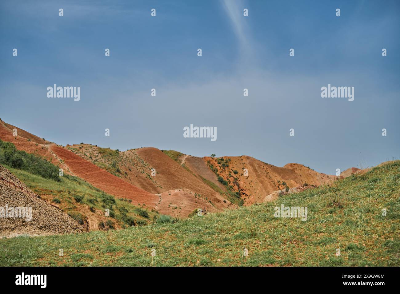 Stunning landscape with colorful hills and lush green fields under blue ...