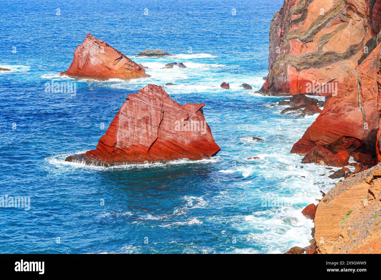Red rock protruding out of the Atlantic Ocean at the Ponta de São ...