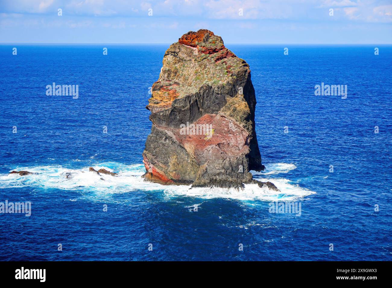 Red rock protruding out of the Atlantic Ocean at the Ponta de São ...