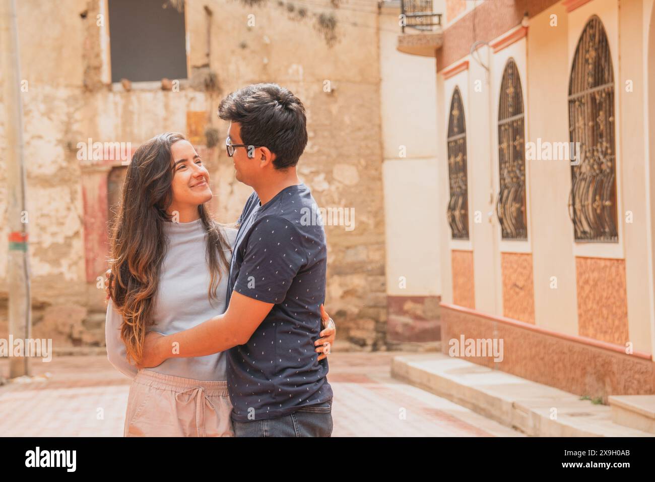 A young couple embracing and looking at each other with love and ...