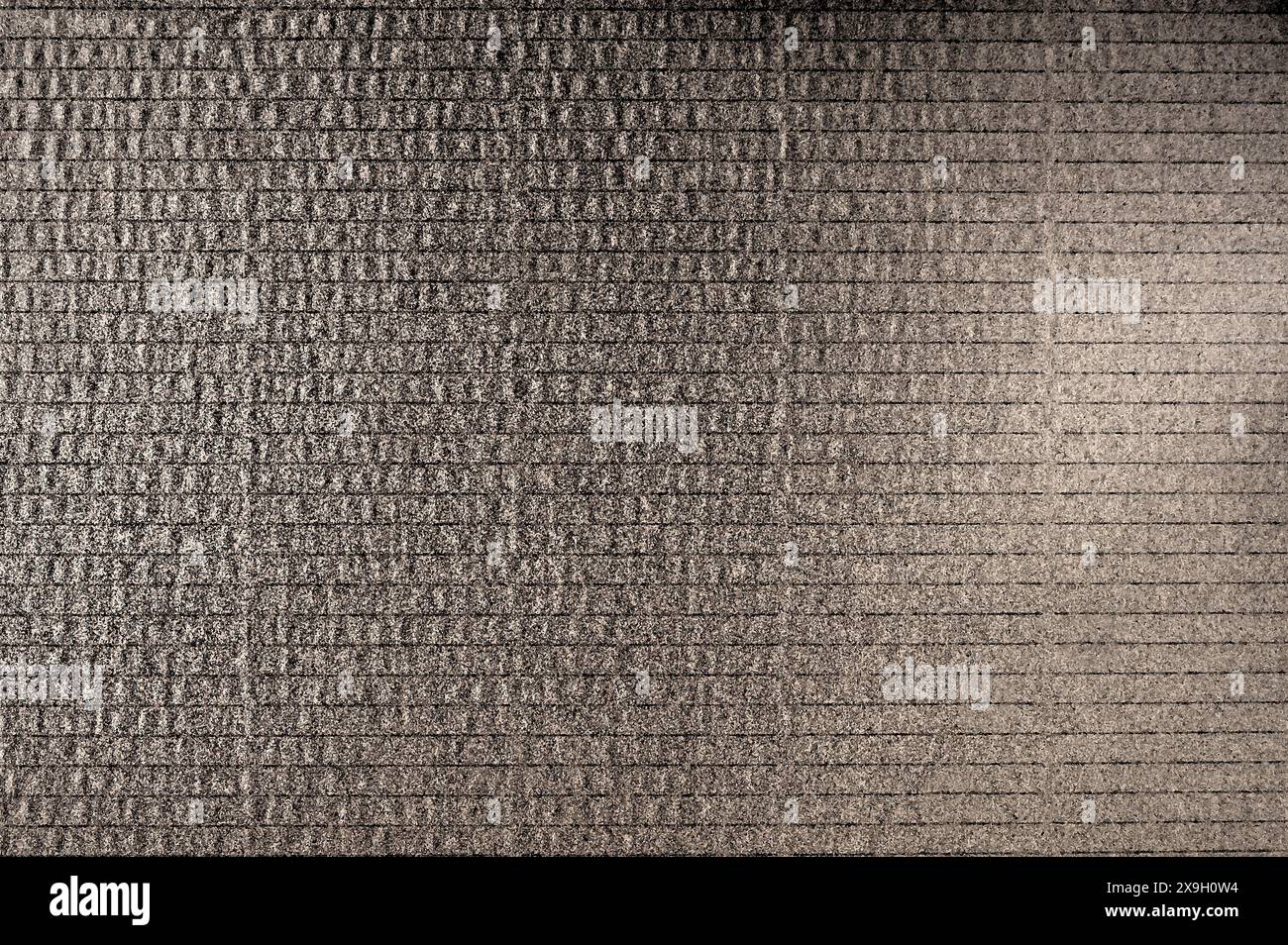 Concrete wall with a grid-like pattern and rough texture, exhibiting an ...