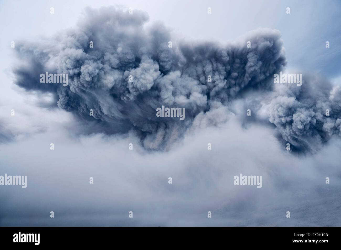 Massive cloud of ash and smoke from a volcanic eruption fills the sky ...