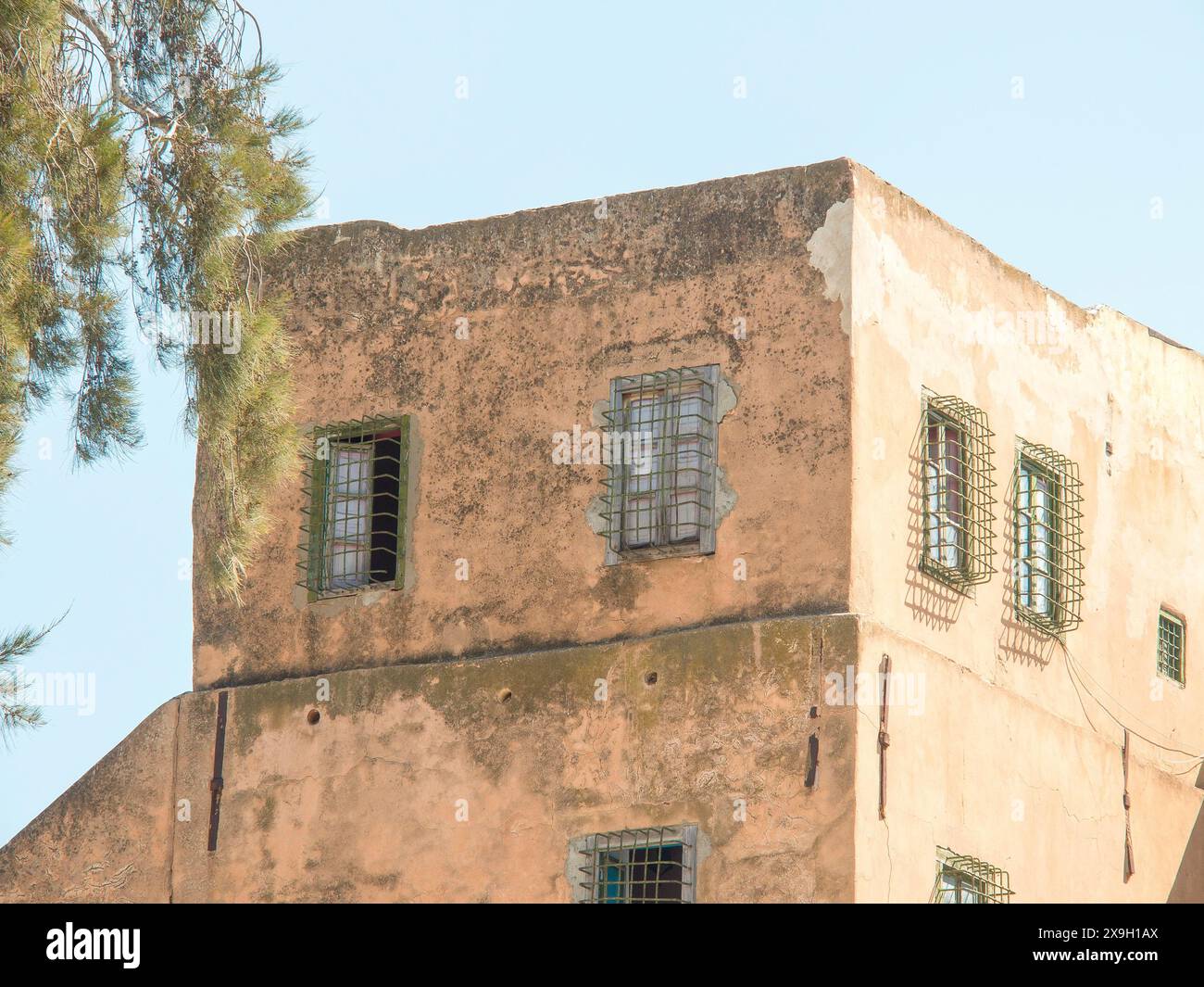 The traditional building made of earth and stone walls shows windows ...