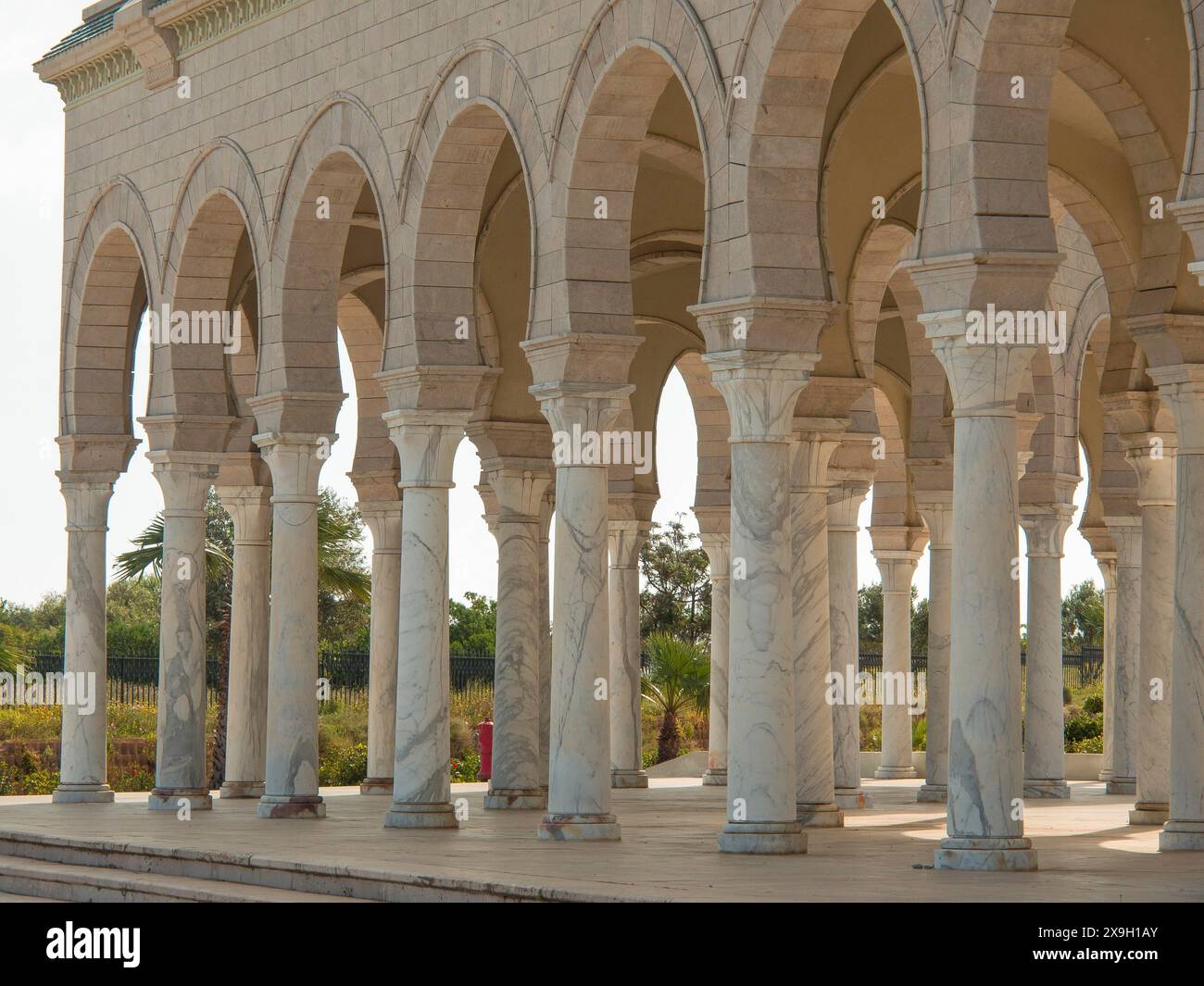 The exterior of a building with marble columns and arches in bright ...