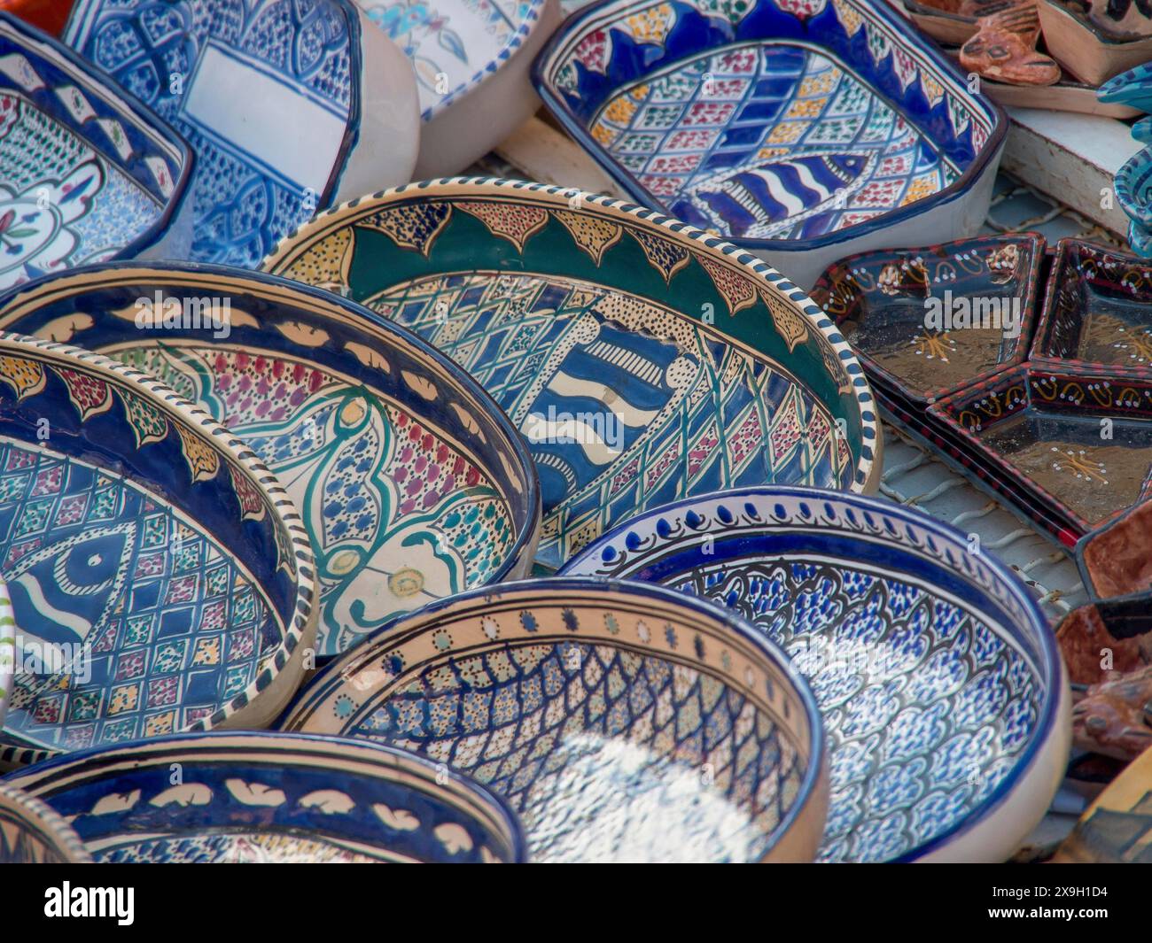 Colourfully painted, traditional ceramic bowls and plates with various ...