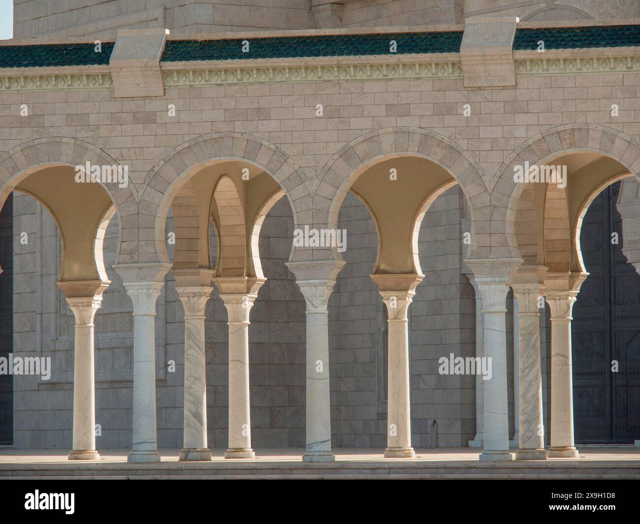 Sandstone columns and arcades with arches that cast shadows in daylight ...