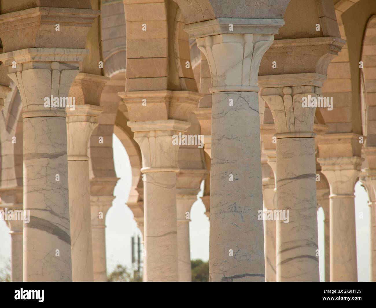 Several beige columns of an ancient arcade with shadow plays in the ...