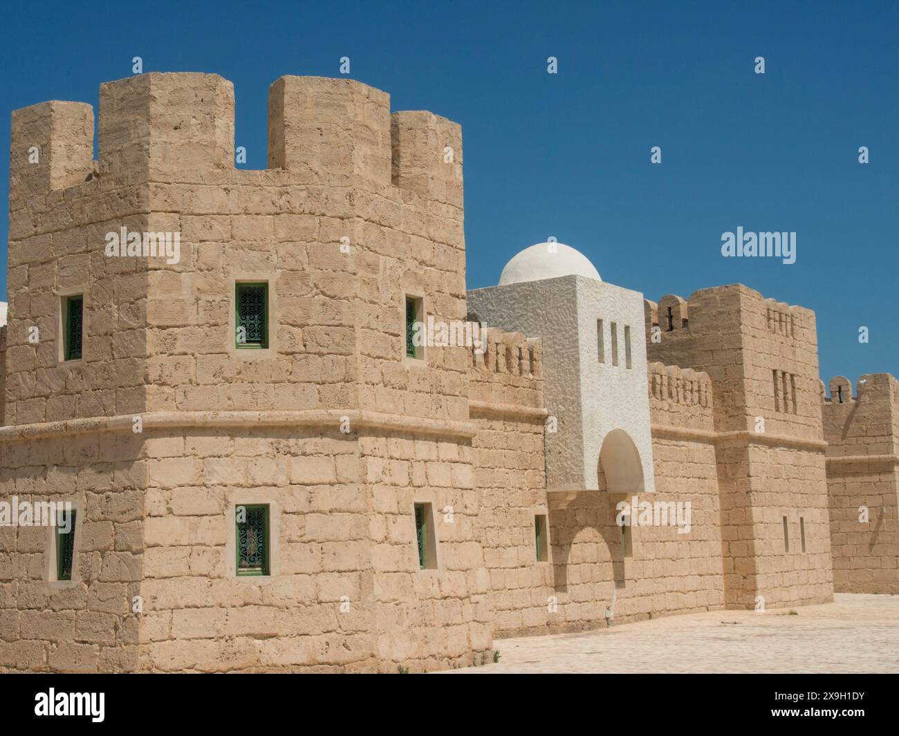 Stone fortress with high walls and towers under a clear blue sky ...