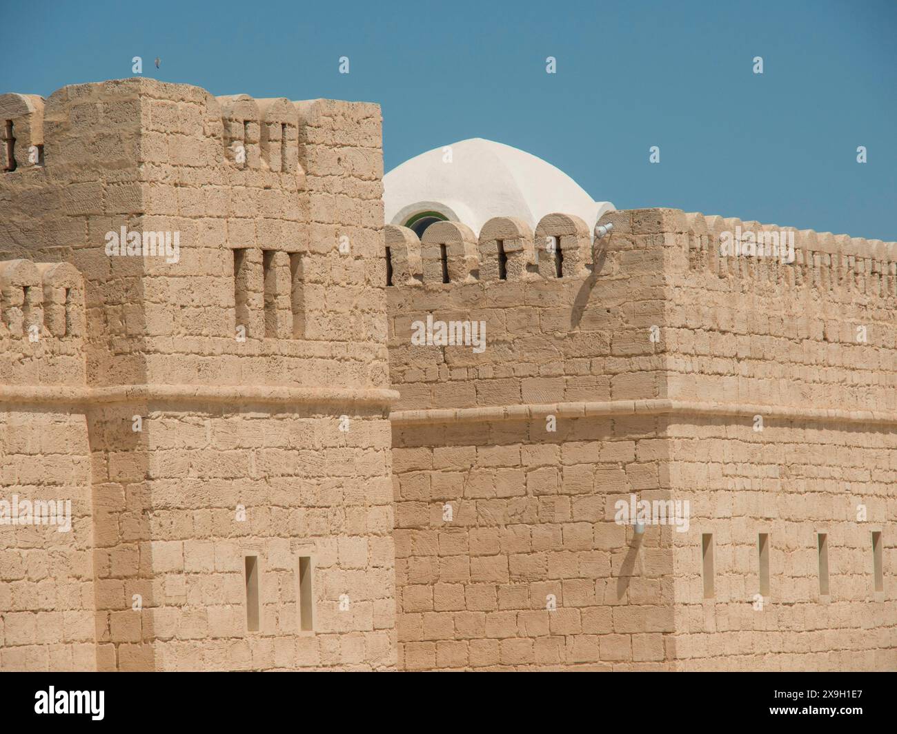 Stone walls of a historic fortress or castle with dome and clear sky ...