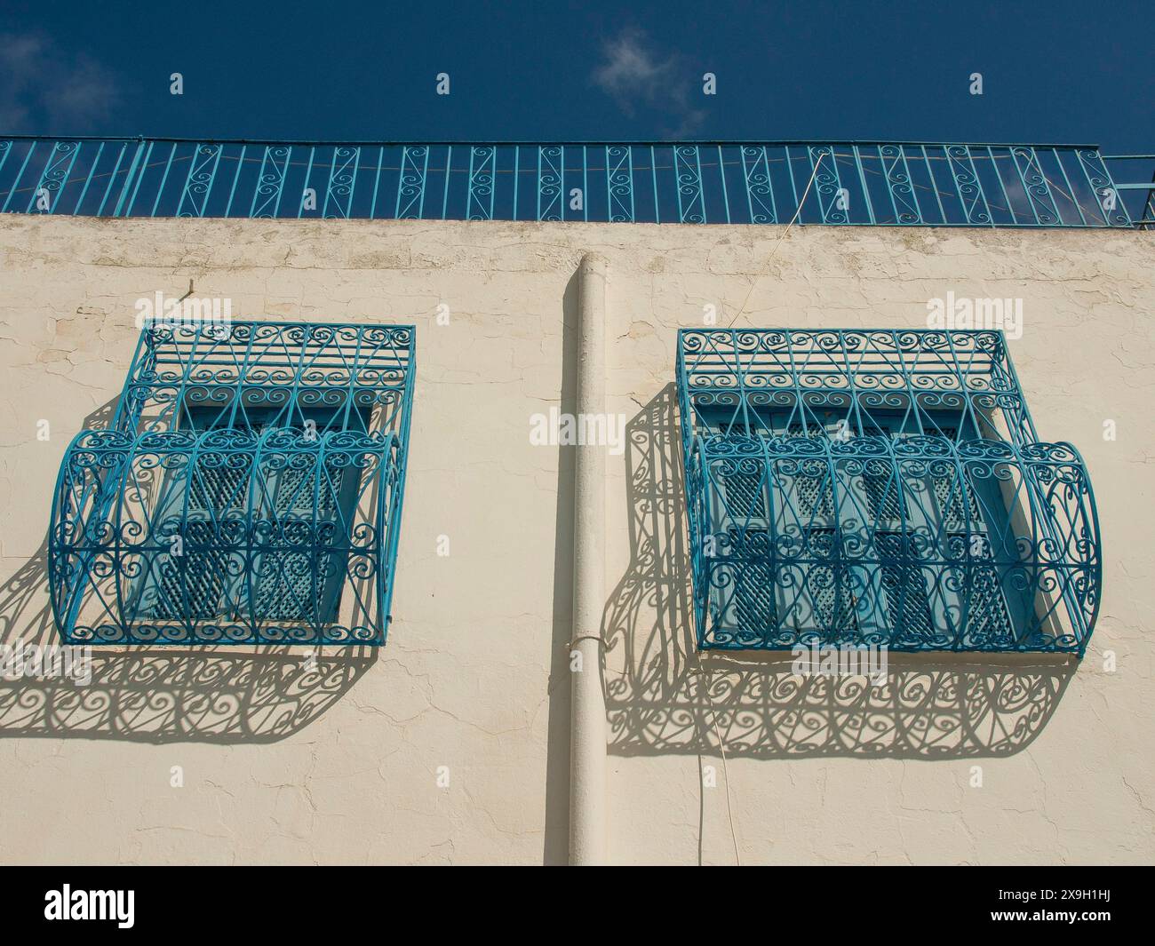 Decorative blue balconies on a white wall cast shadows, Tunis in Africa ...