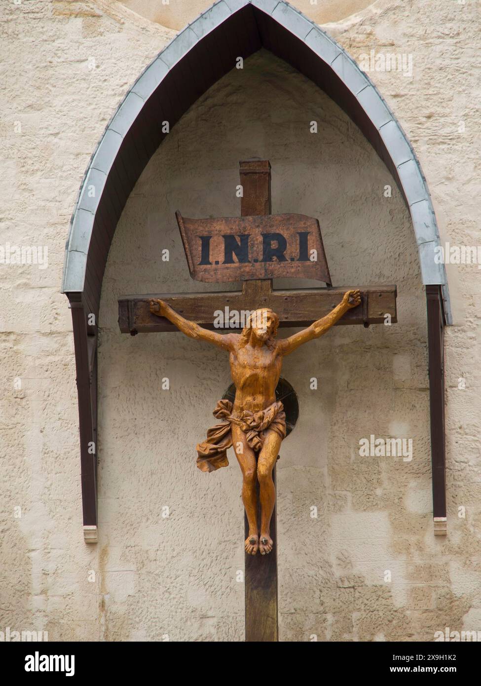 Wooden cross with Jesus sculpture and INRI sign on a church wall ...