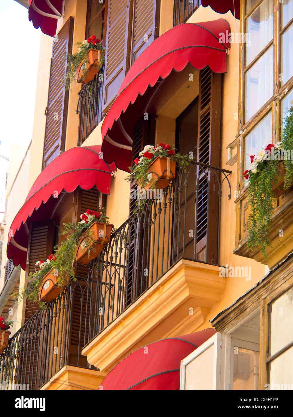 Buildings with red awnings, flowers and decorative balconies, palma de ...