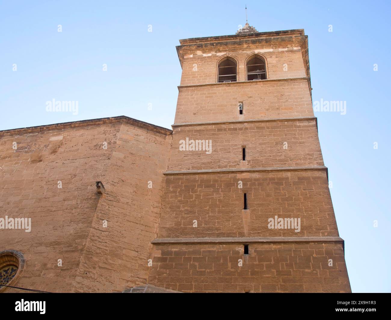 A historic sandstone church tower standing out against a blue sky ...