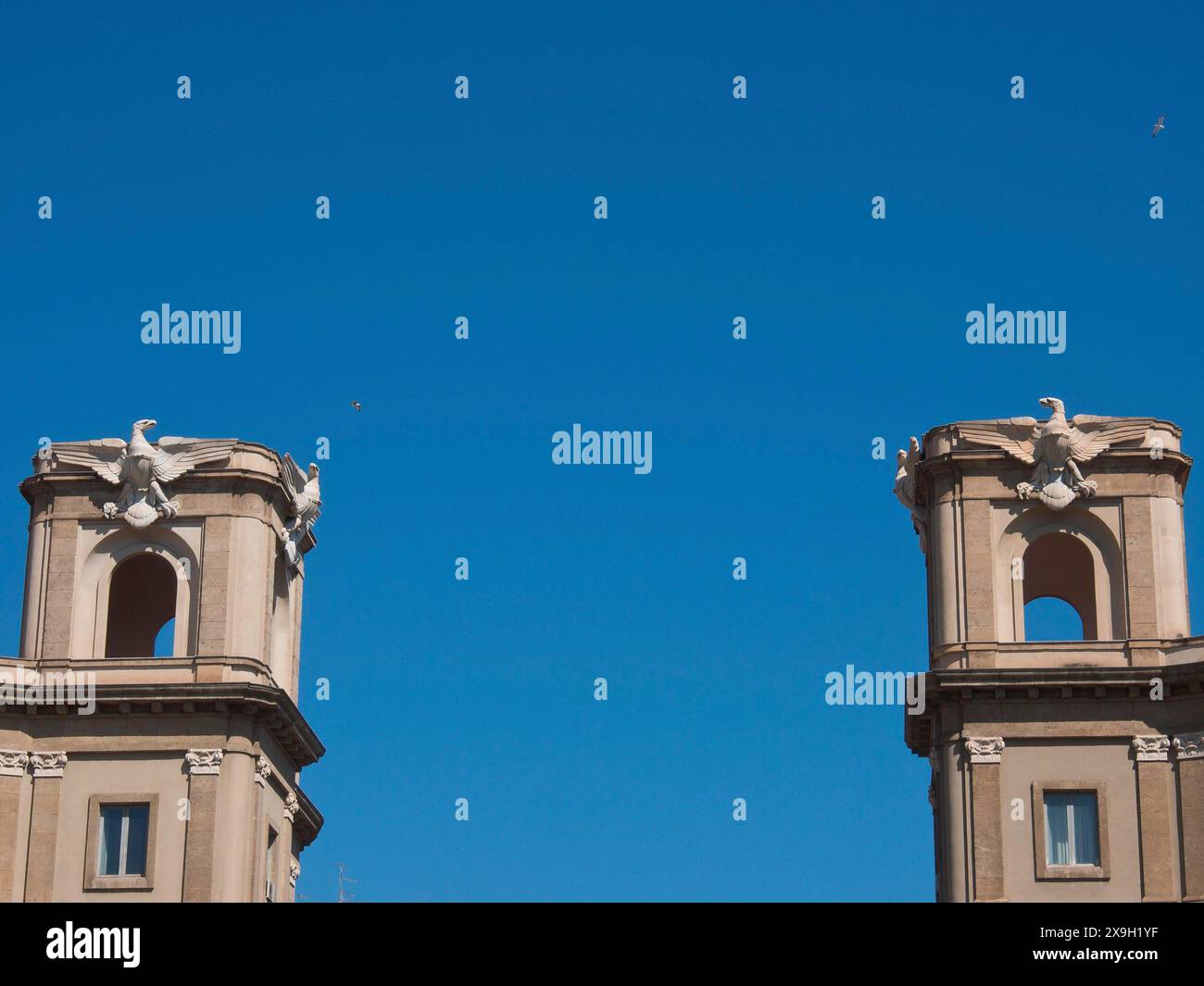 Two symmetrical building towers with sculptures and ornate stonework ...