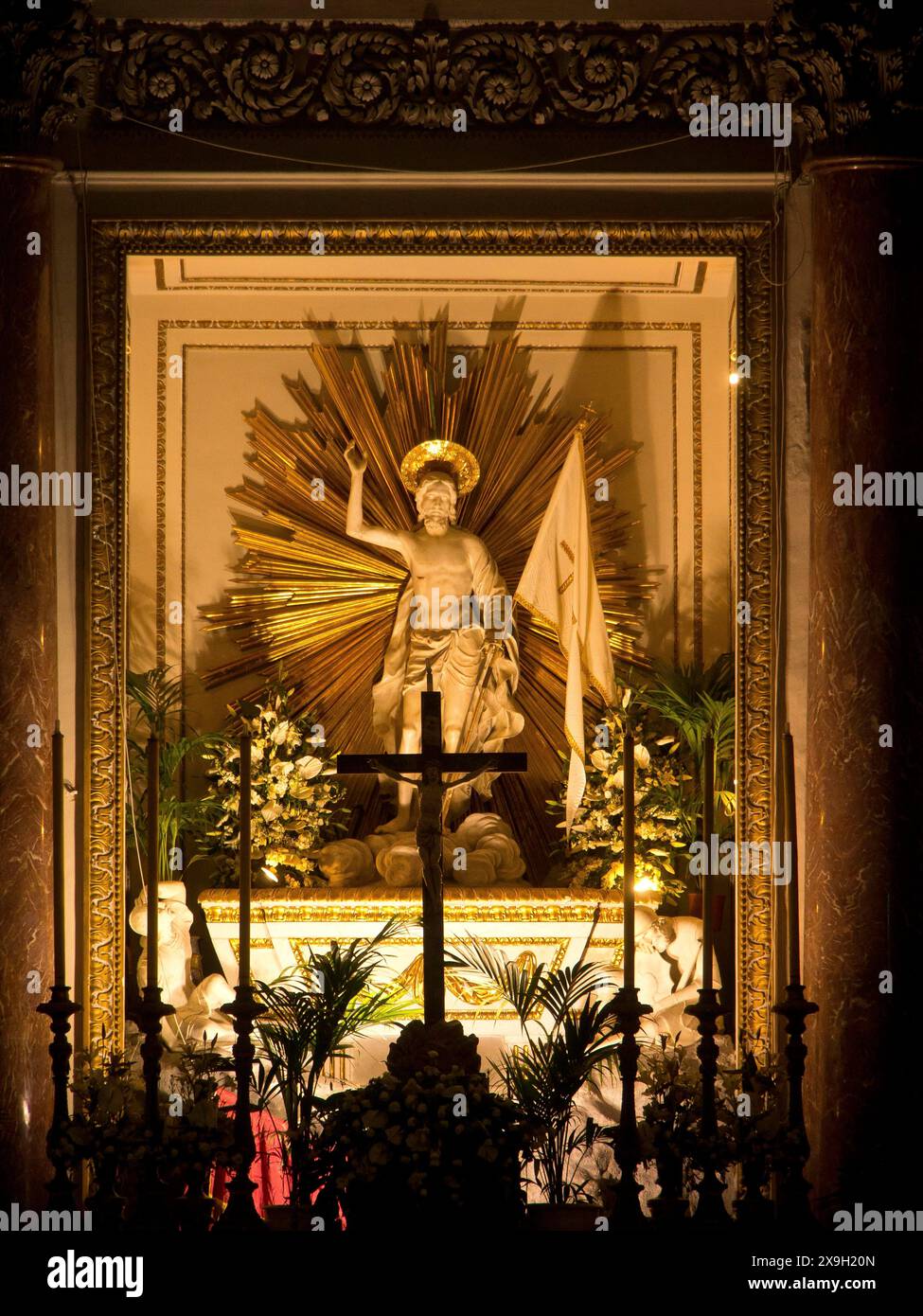 Magnificently decorated altar with statue of a saint and golden rays ...