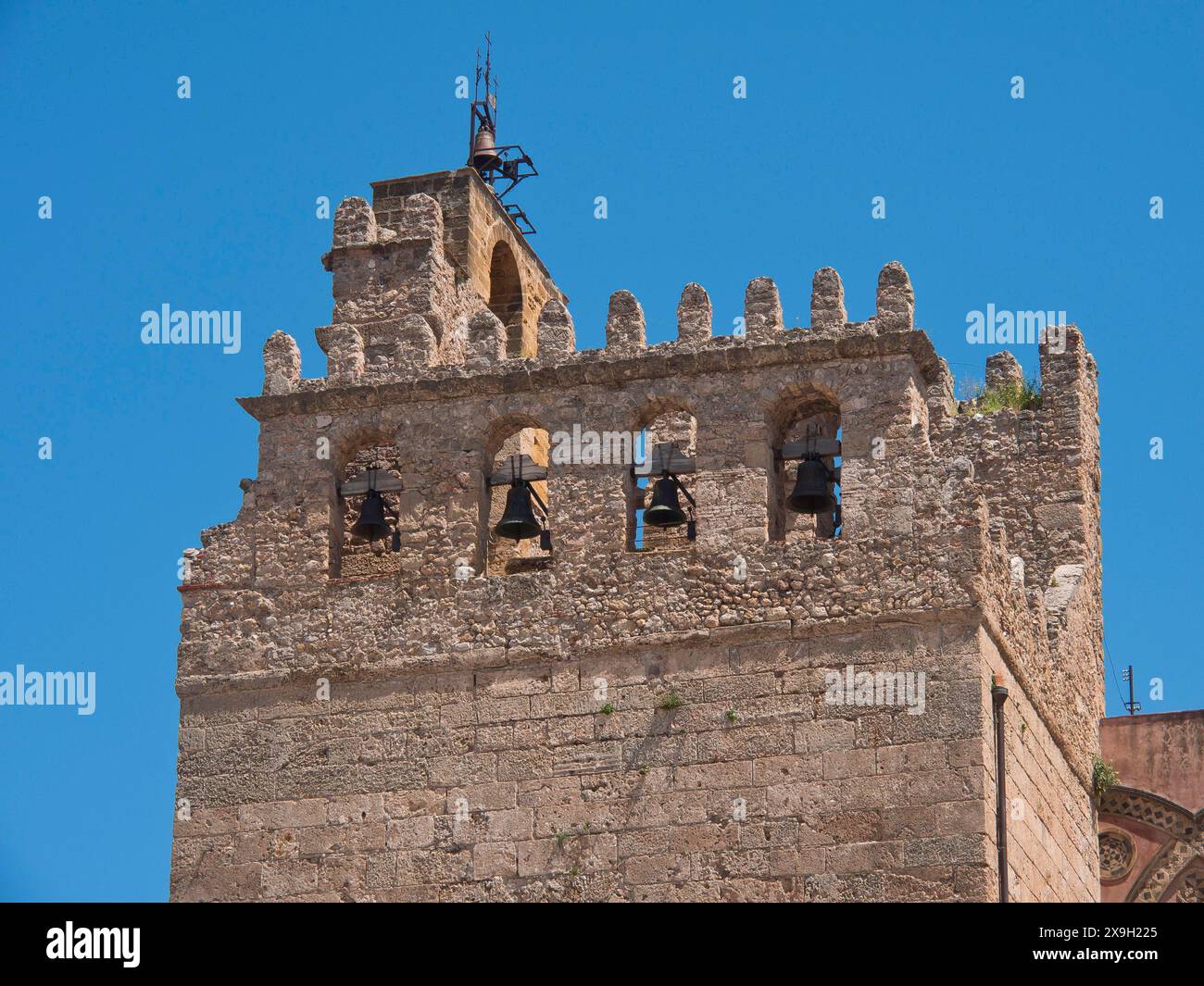 An old stone tower with bells against a clear blue sky, palermo in ...