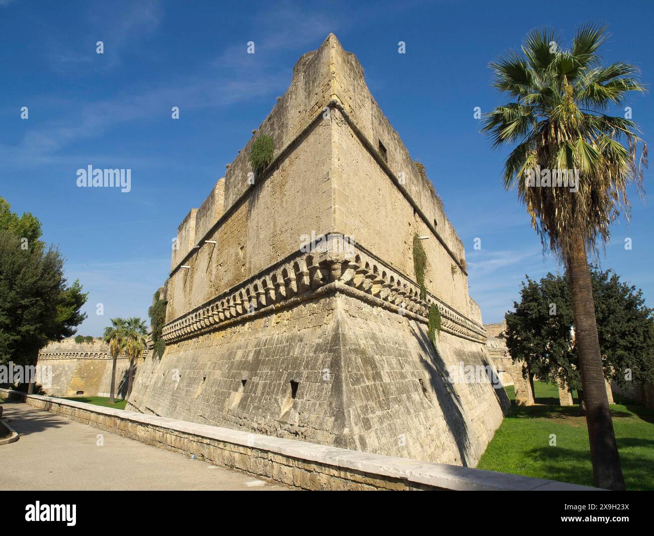 Old fortress wall with trees and green area under the blue sky on a ...