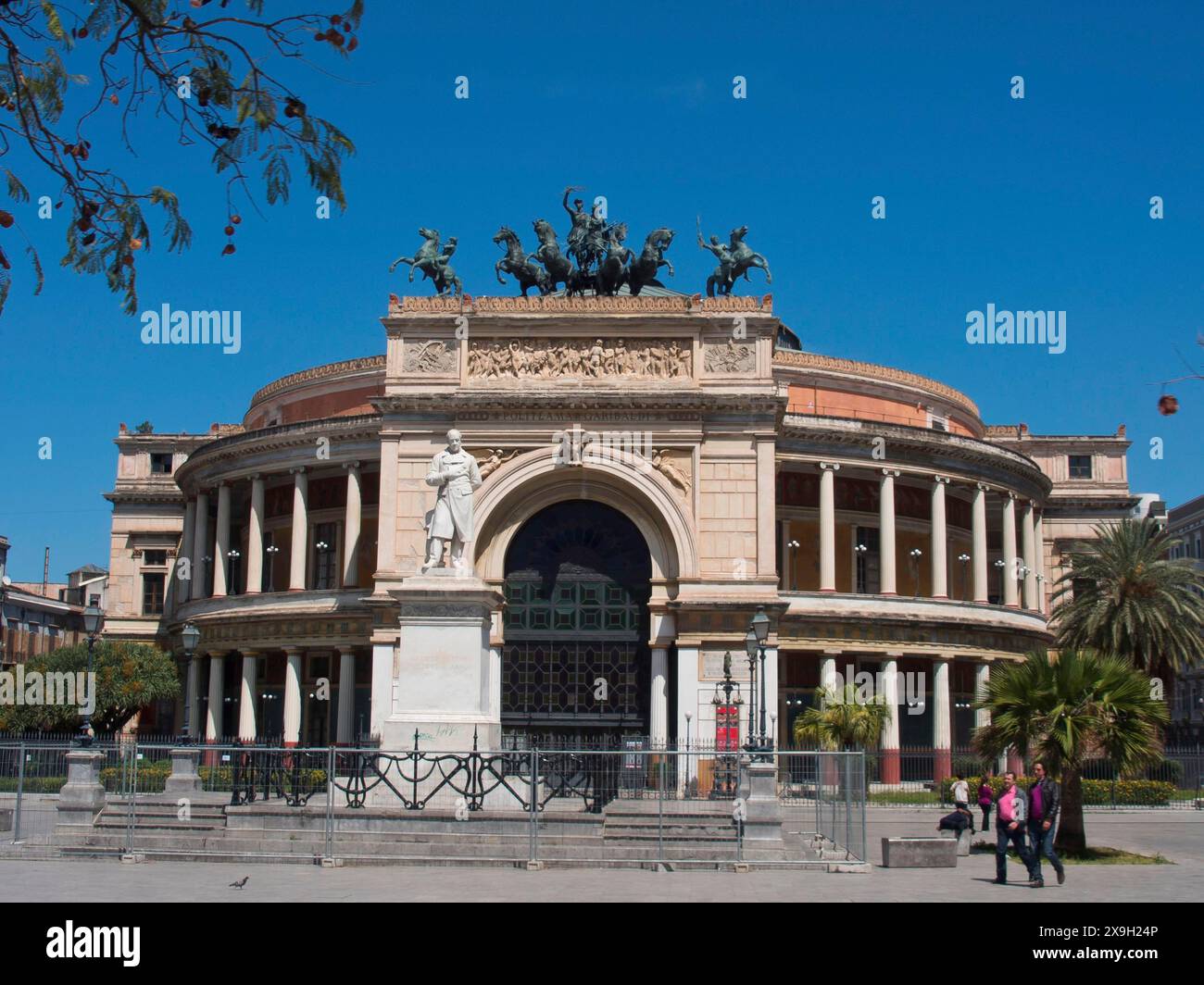 A large, round historical building with a statue and columns on a sunny ...