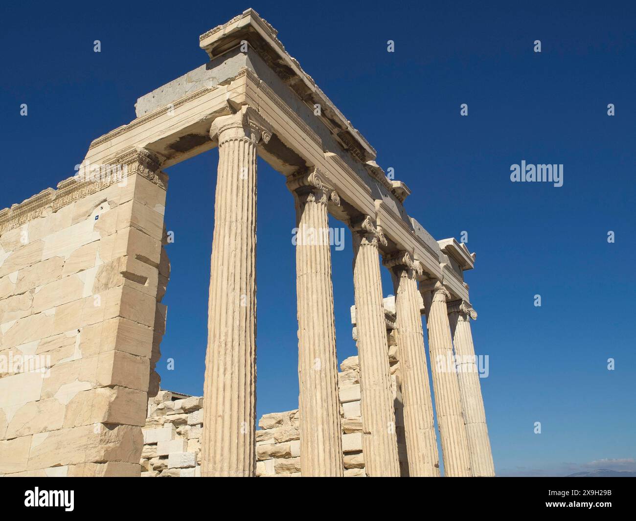 Ancient temple columns against a deep blue sky, Ancient buildings with columns and trees on the ...