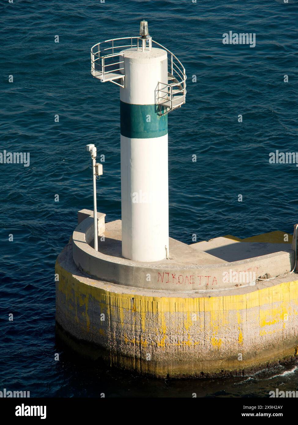 White-green lighthouse in the sea on a concrete base, Ancient building ...