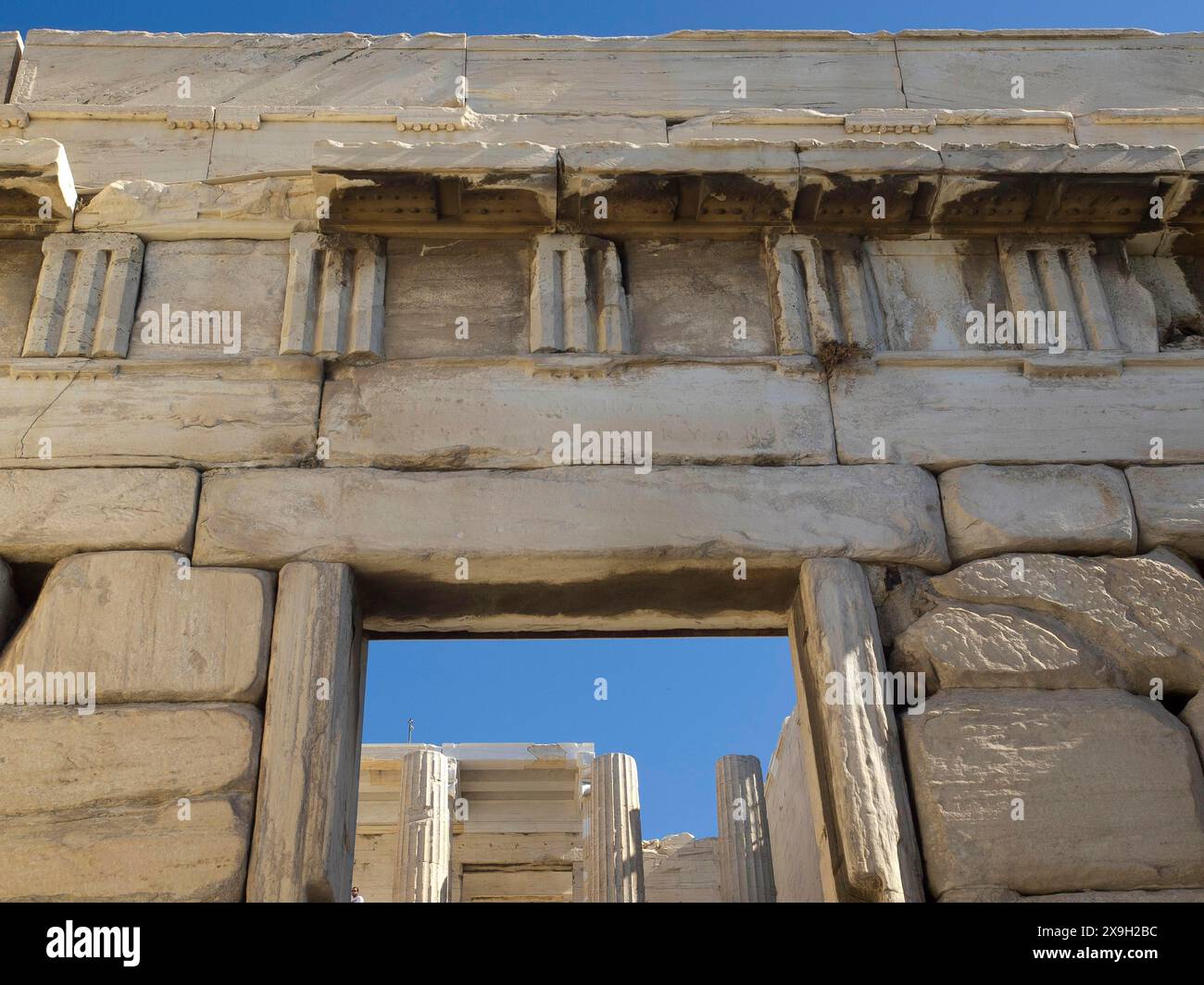 Ancient columns and stone structures forming a Tor tor under a bright blue sky, Ancient ...