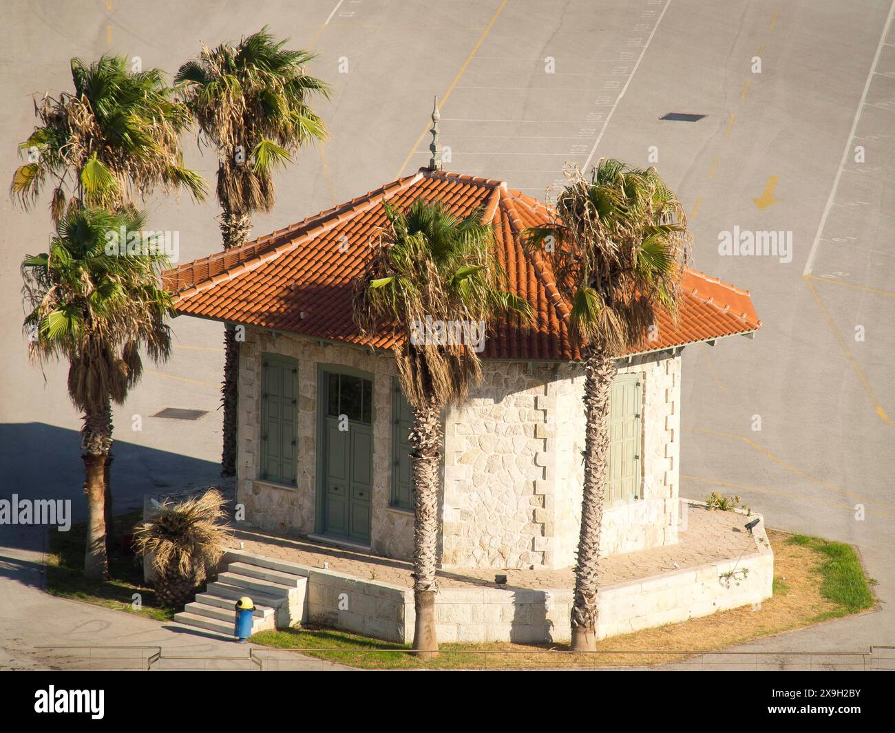 Small pavilion with red roof tiles surrounded by palm trees on an ...