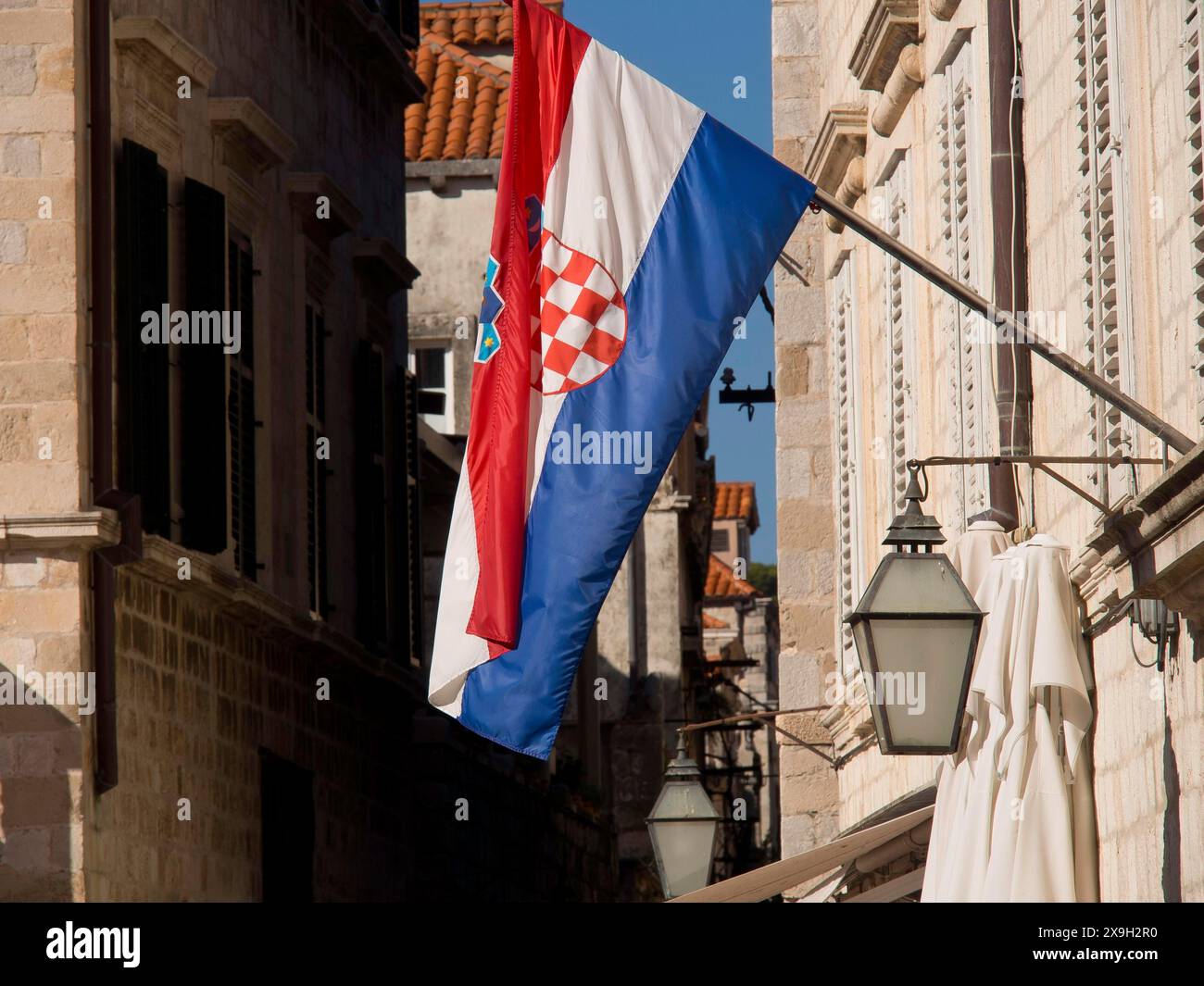 Croatian flag waving in a narrow alley with historic buildings and ...