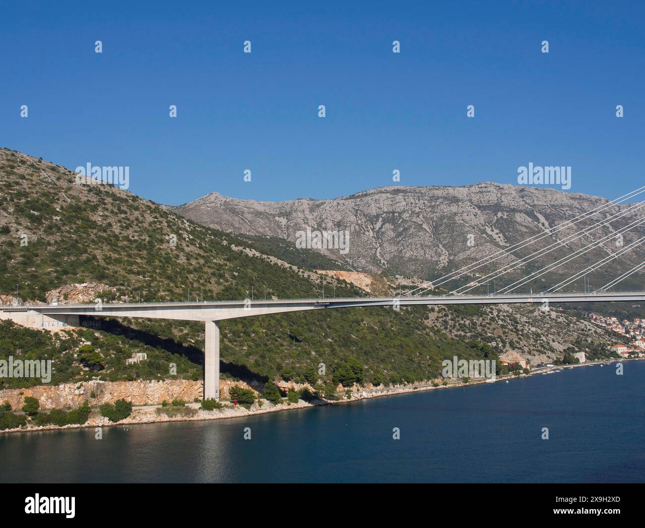 Long, modern bridge spanning a river in a picturesque mountain ...