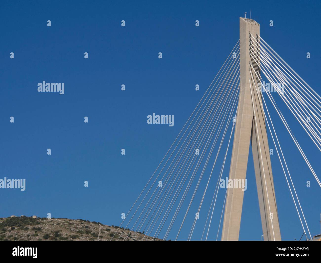 Detailed view of a modern cable bridge in front of a cloudless blue sky ...