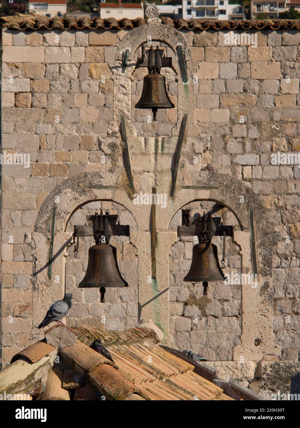 Three bells on an old stone wall, detail from a medieval town, the old ...