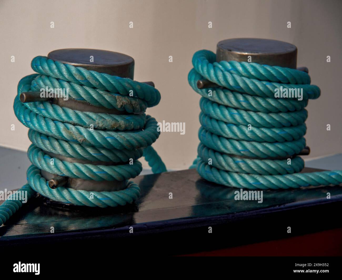 Close-up of two blue-wrapped mooring lines on a boat, historic houses ...